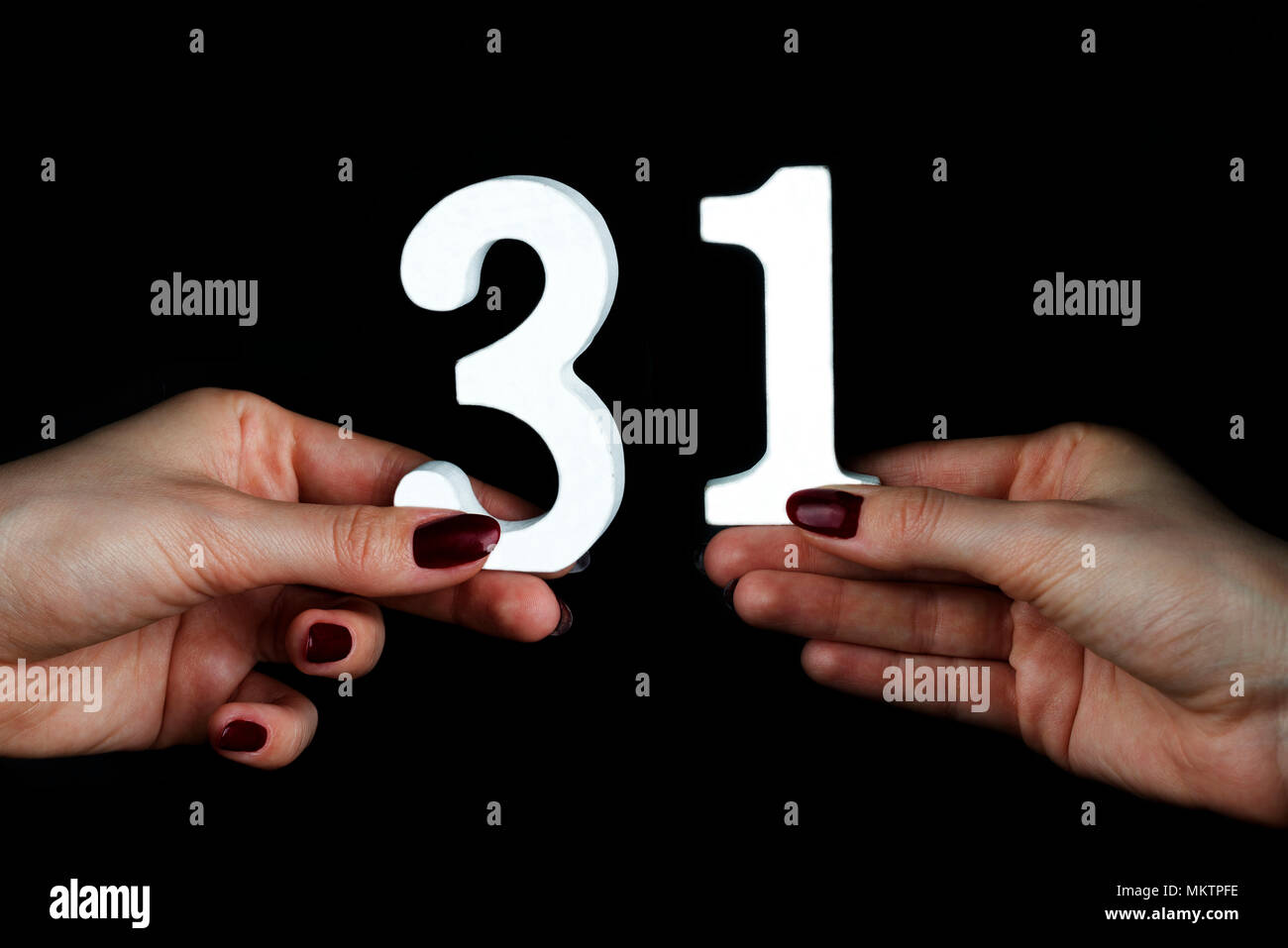 On a black background, female hand with number thirty-one Stock Photo ...