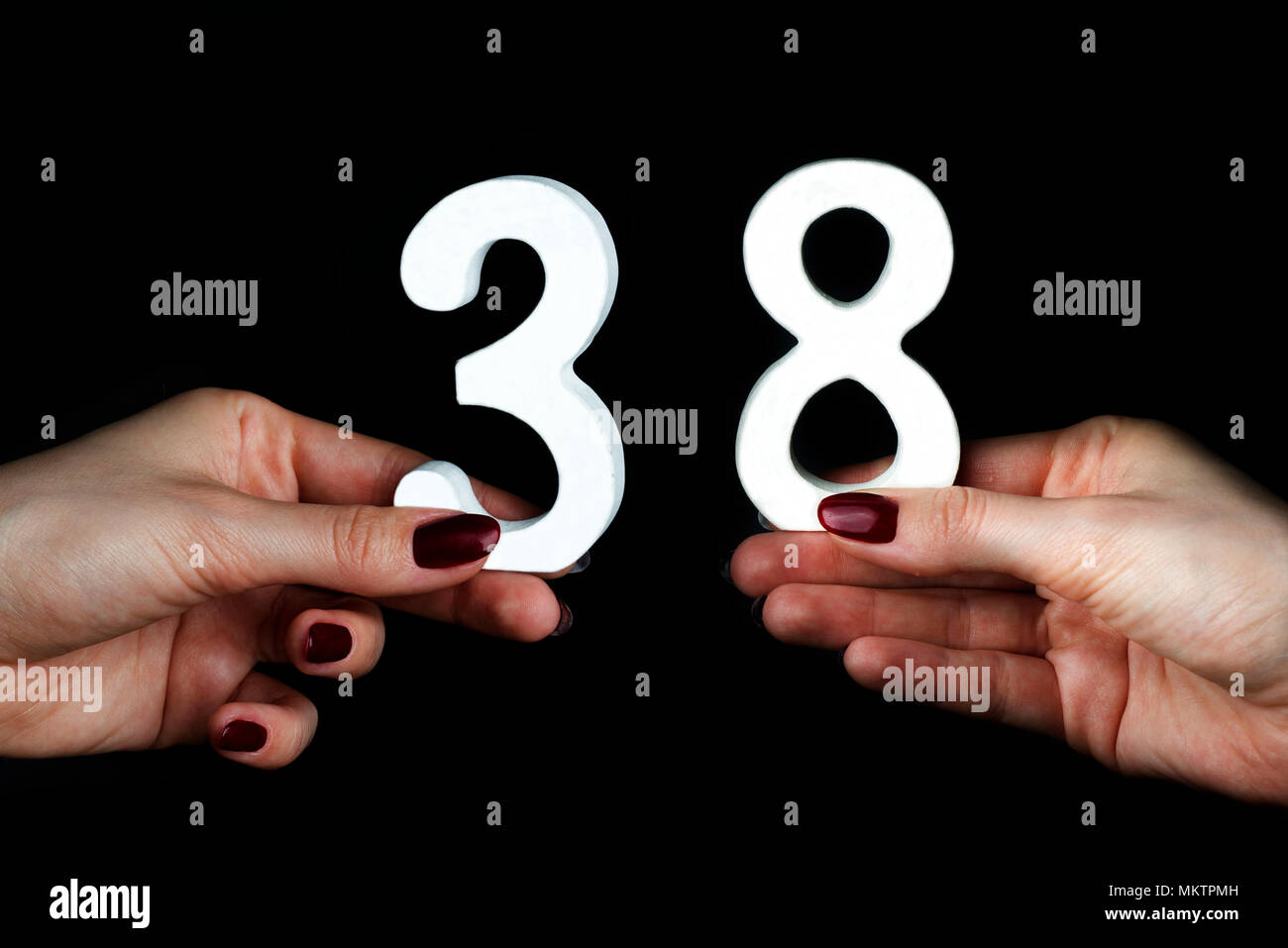 On a black background, female hand with number thirty-eight Stock Photo ...