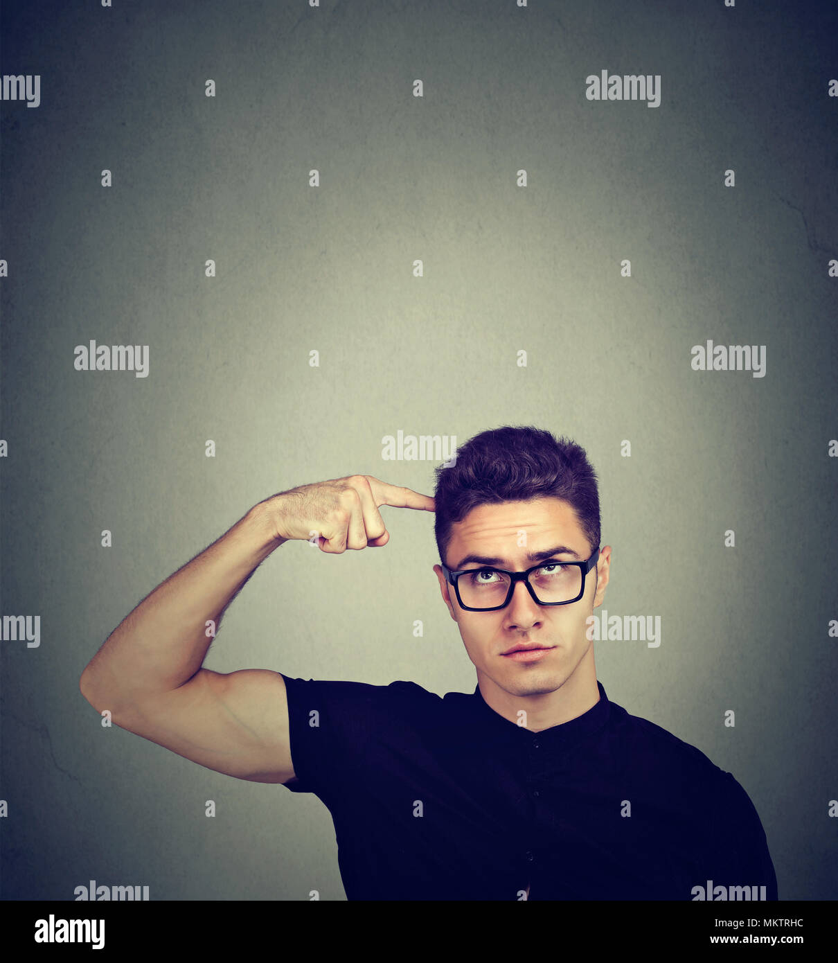 Thinking perplexed man looking up isolated on gray wall background ...