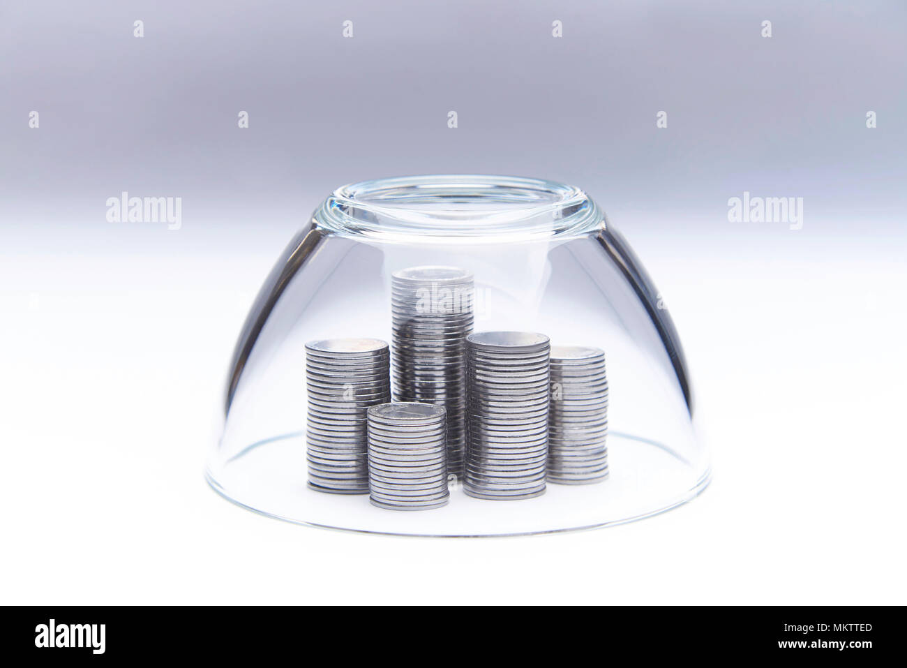 Stacks of stacked silver coins under a glass dome Stock Photo - Alamy