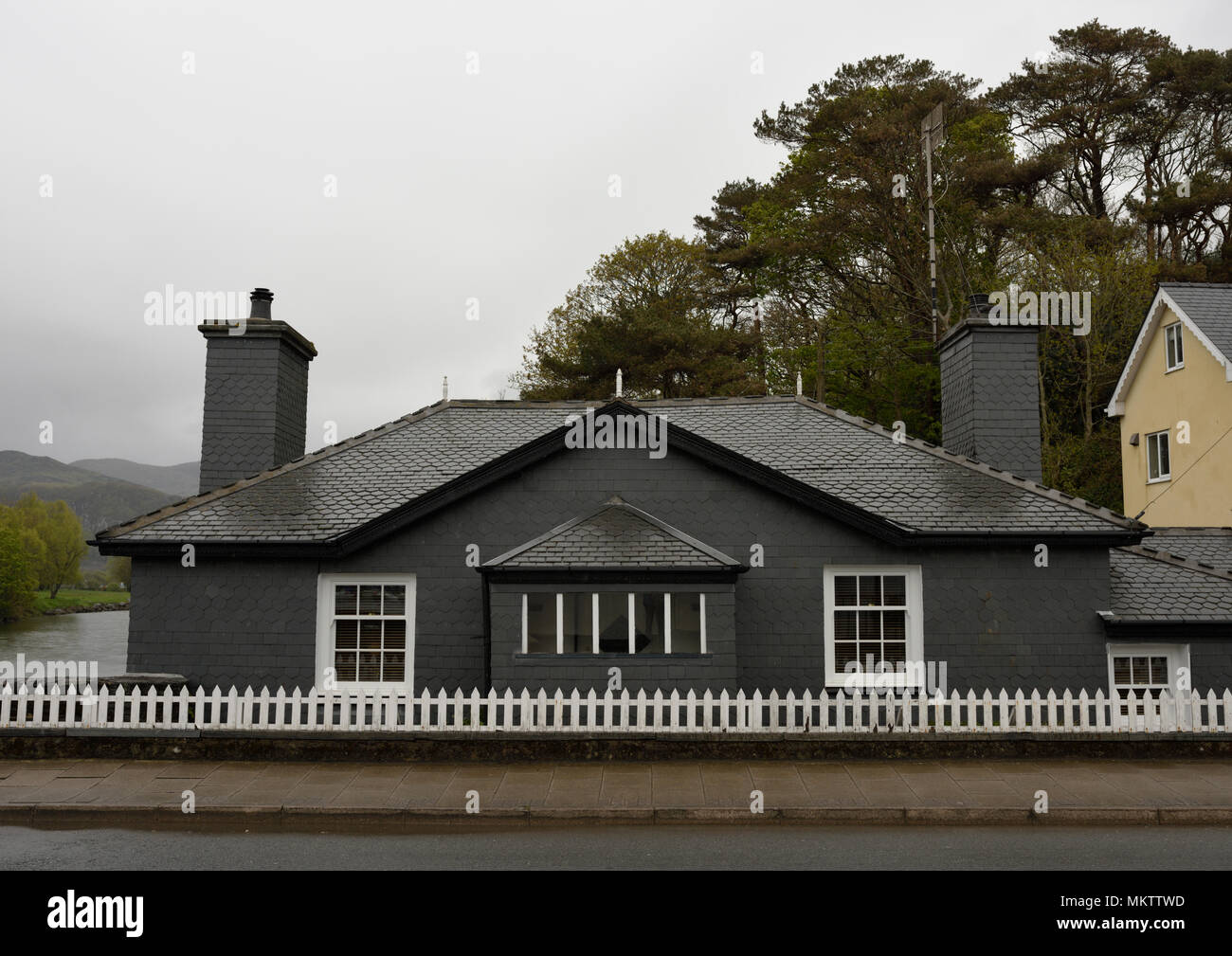 Slate house with two chimney stacks and white wooden picket fence ...