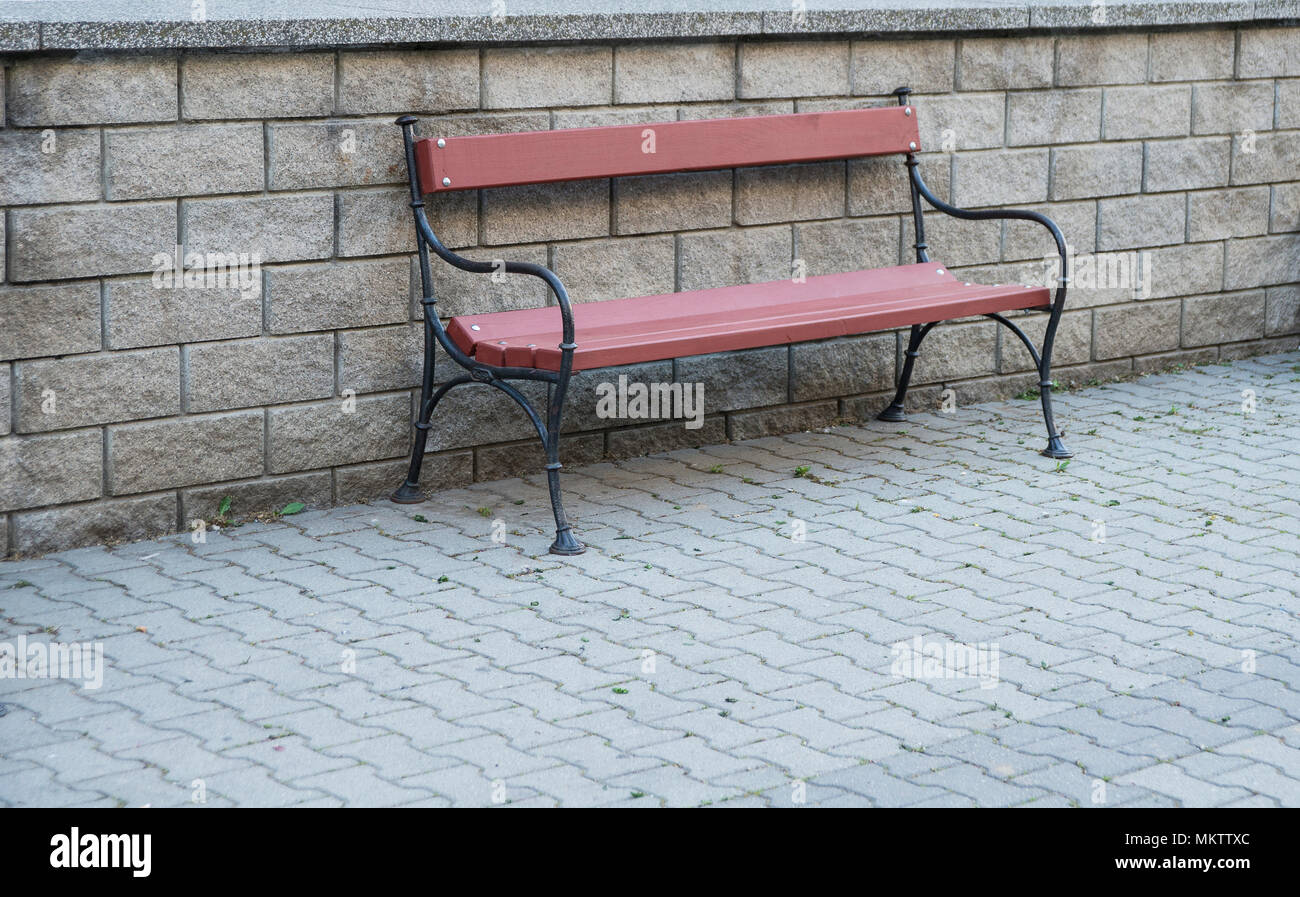 Empty metal and wooden bench in the town Stock Photo - Alamy