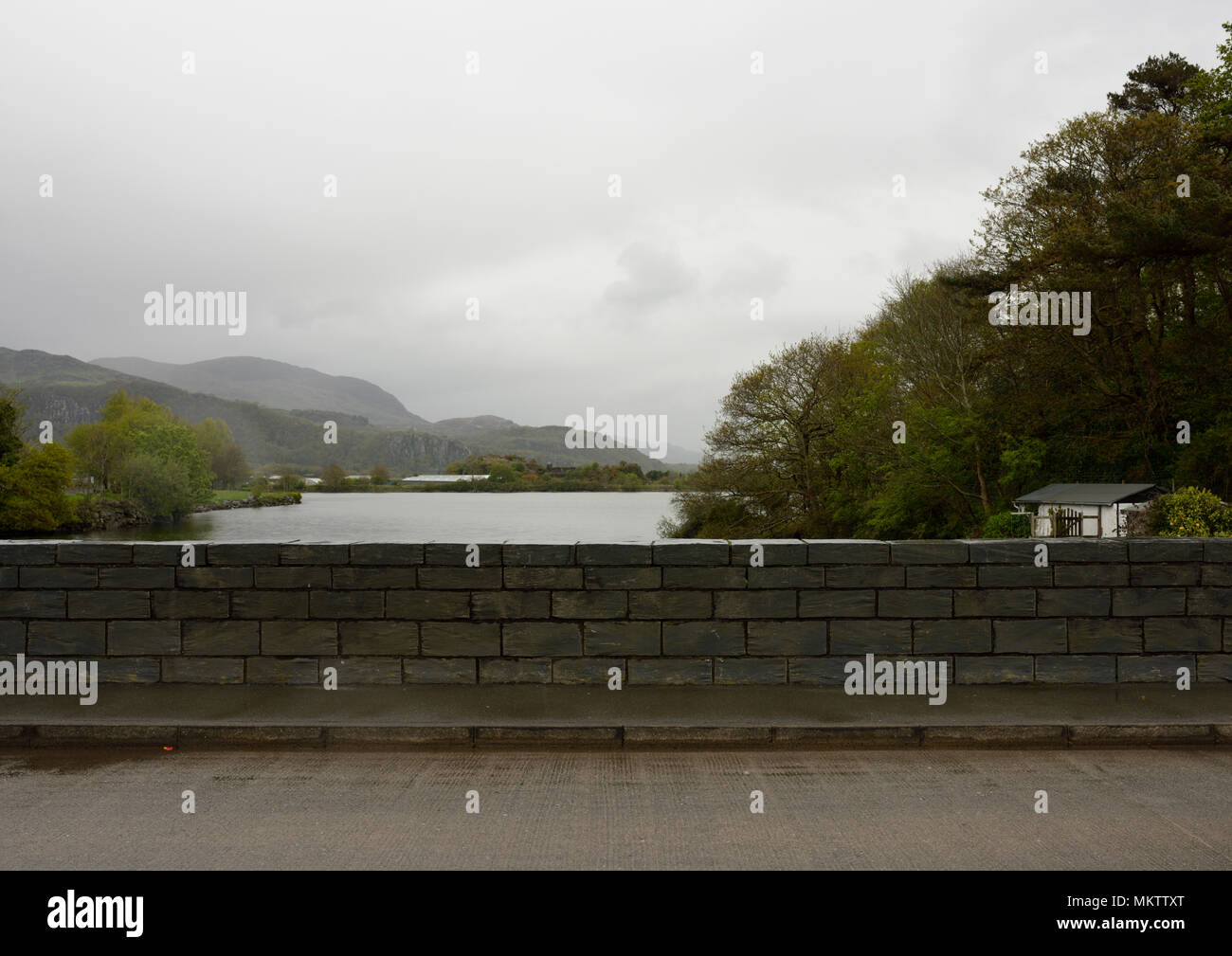 Slate wall on bridge with Snowdonia national park, mountains and trees ...