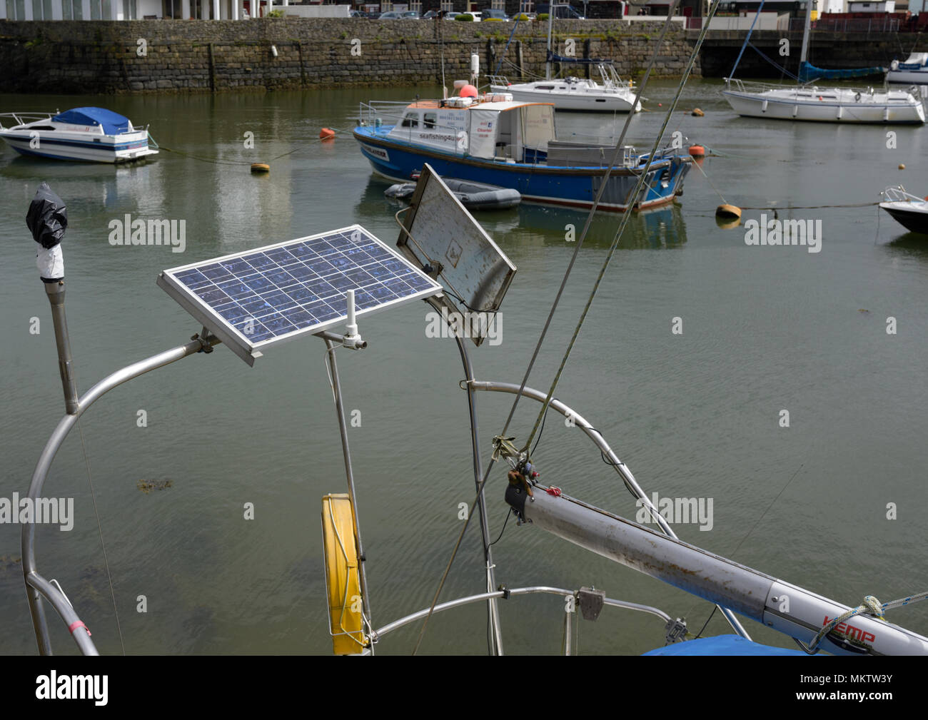 Solar panel mounted at stern of sailing boat with boats at anchor in ...