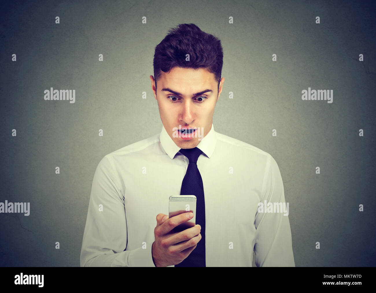 Shocked business man checking his phone Stock Photo - Alamy