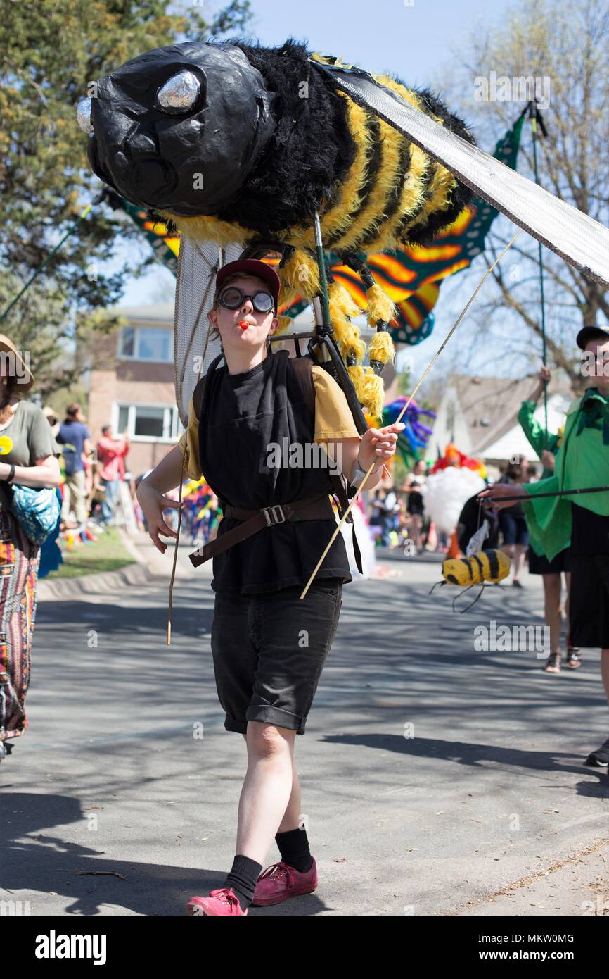 A person with a giant bee puppet at the May Day parade and festival in ...