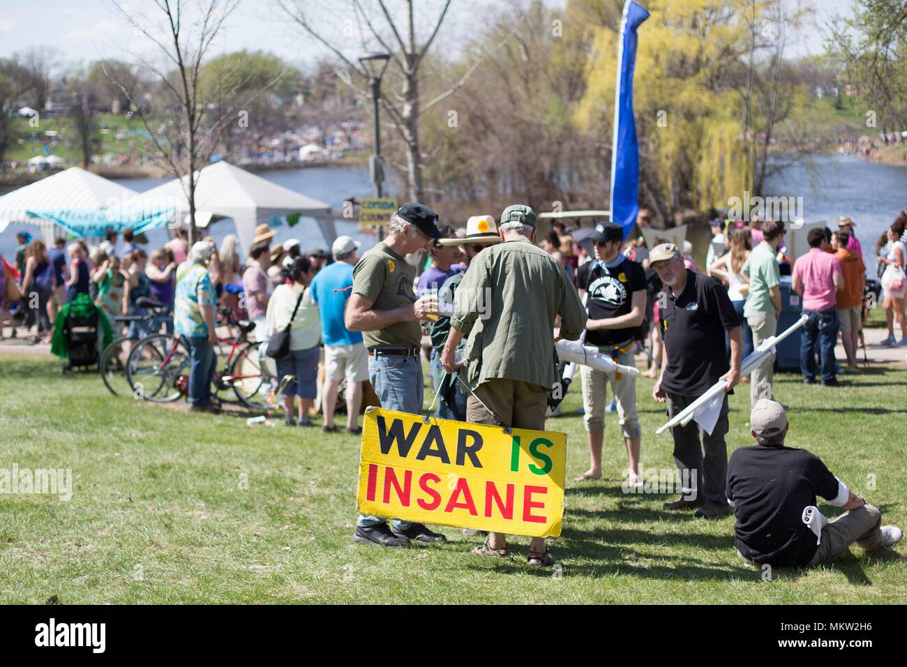 A man holding a sign that reads "War is Insane" at the May Day parade ...
