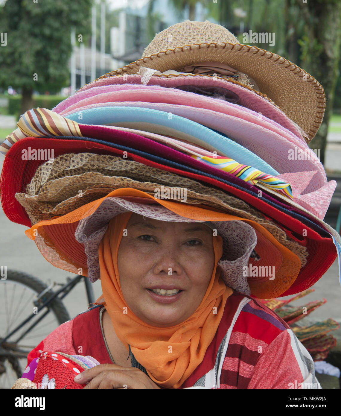Close-up hat seller wearing hats on head outside Borobudur Buddhist ...