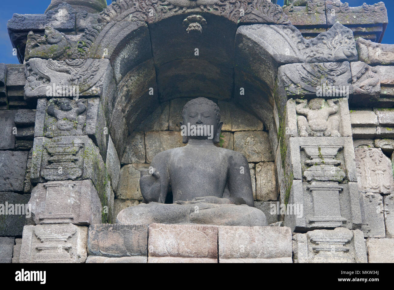 Stone carving seated Buddha in an alcove Borobudur 9th century Buddhist ...