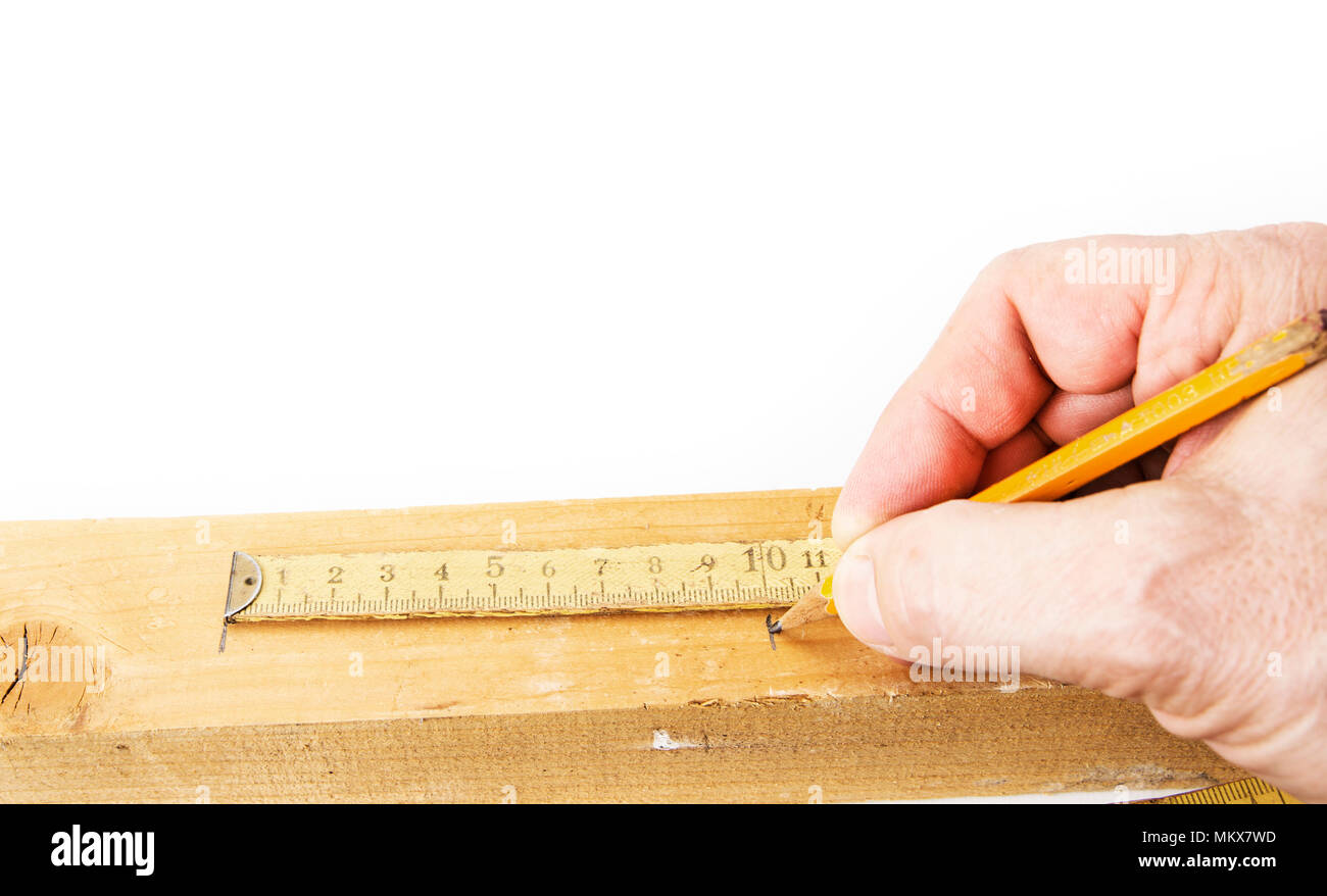 Using old yellow folding meter to measure wood to cut Stock Photo - Alamy