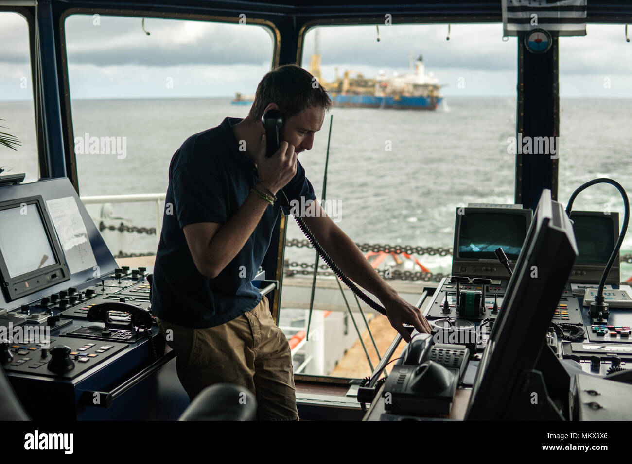 Deck navigation officer on the navigation bridge. He looks through ...