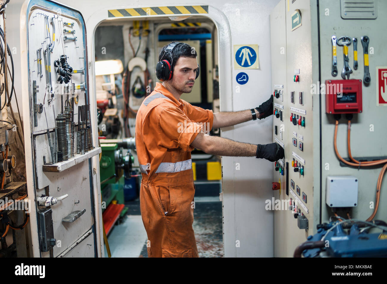 Marine engineer officer controlling vessel engines in engine control ...