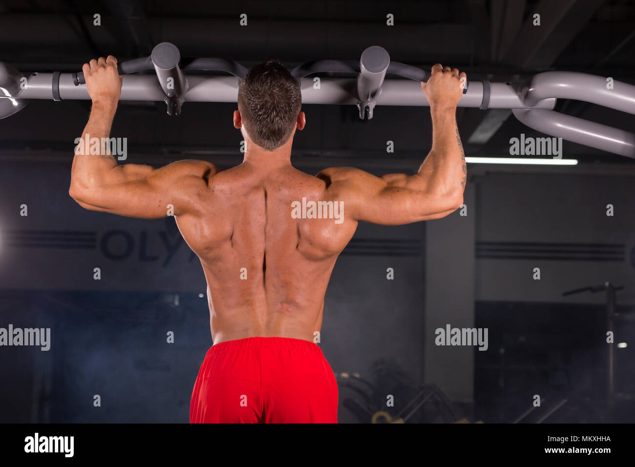 Strong young man doing pull up exercise on horizontal bar in gym Stock ...