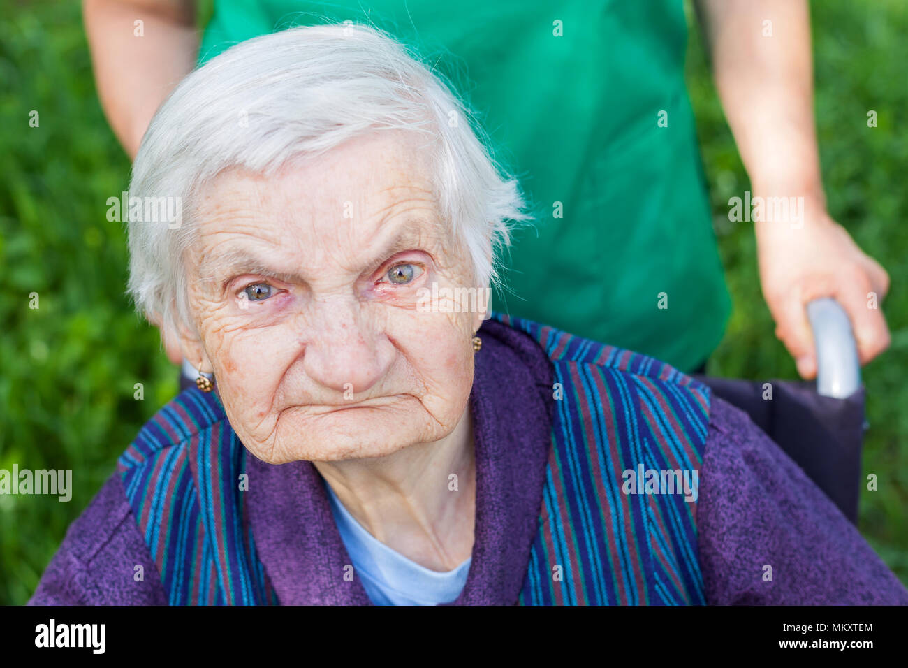 Portrait of elderly disabled woman sitting in a wheelchair spending ...
