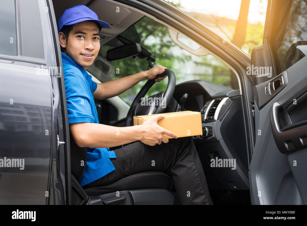 Delivery messenger man with cardboard box outside the warehouse Stock ...