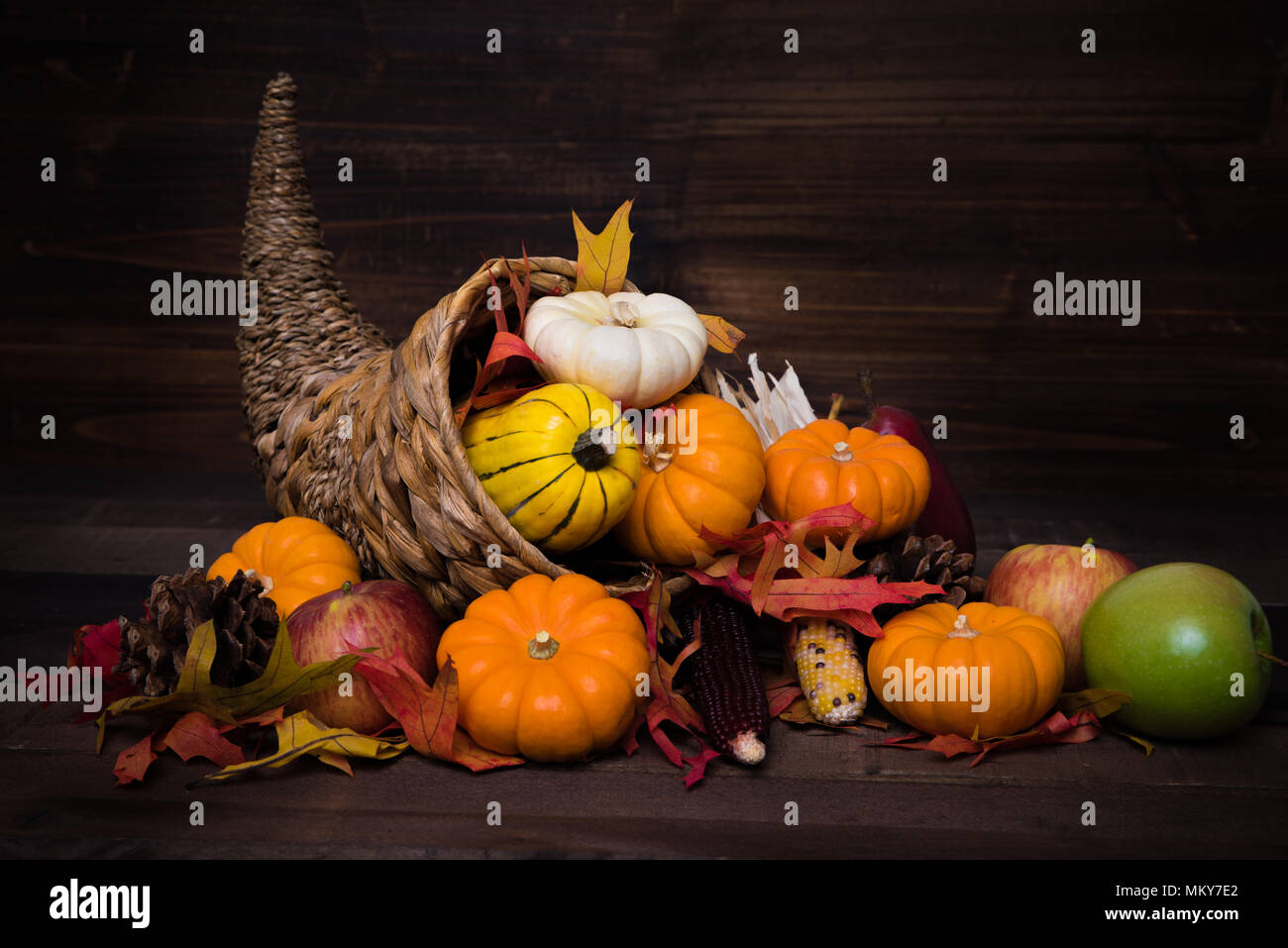 A Thanksgiving holiday decorative cornucopia with pumpkins, squash ...