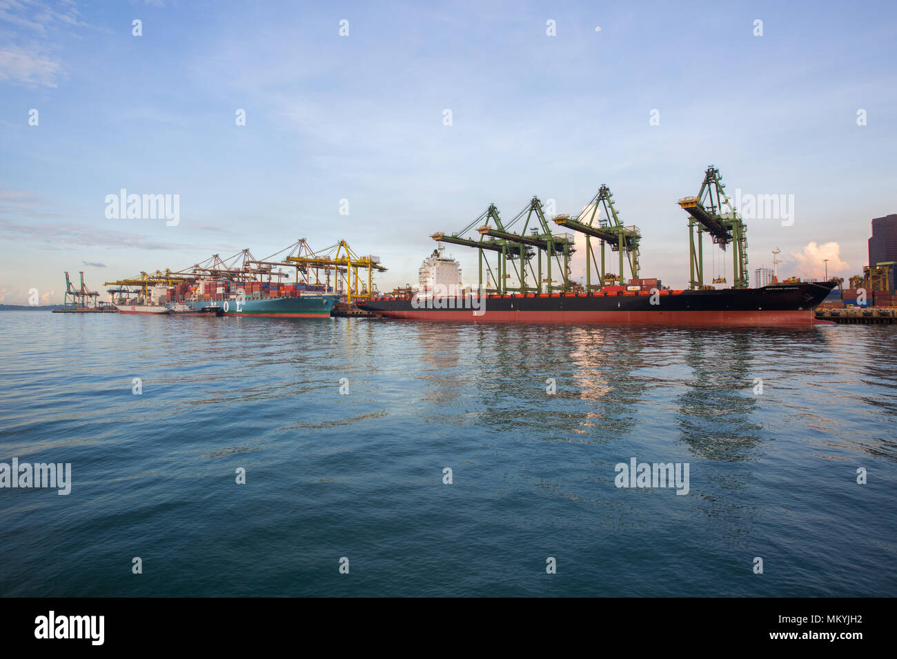 Three vessels dock in a row on Singapore port facility Stock Photo - Alamy