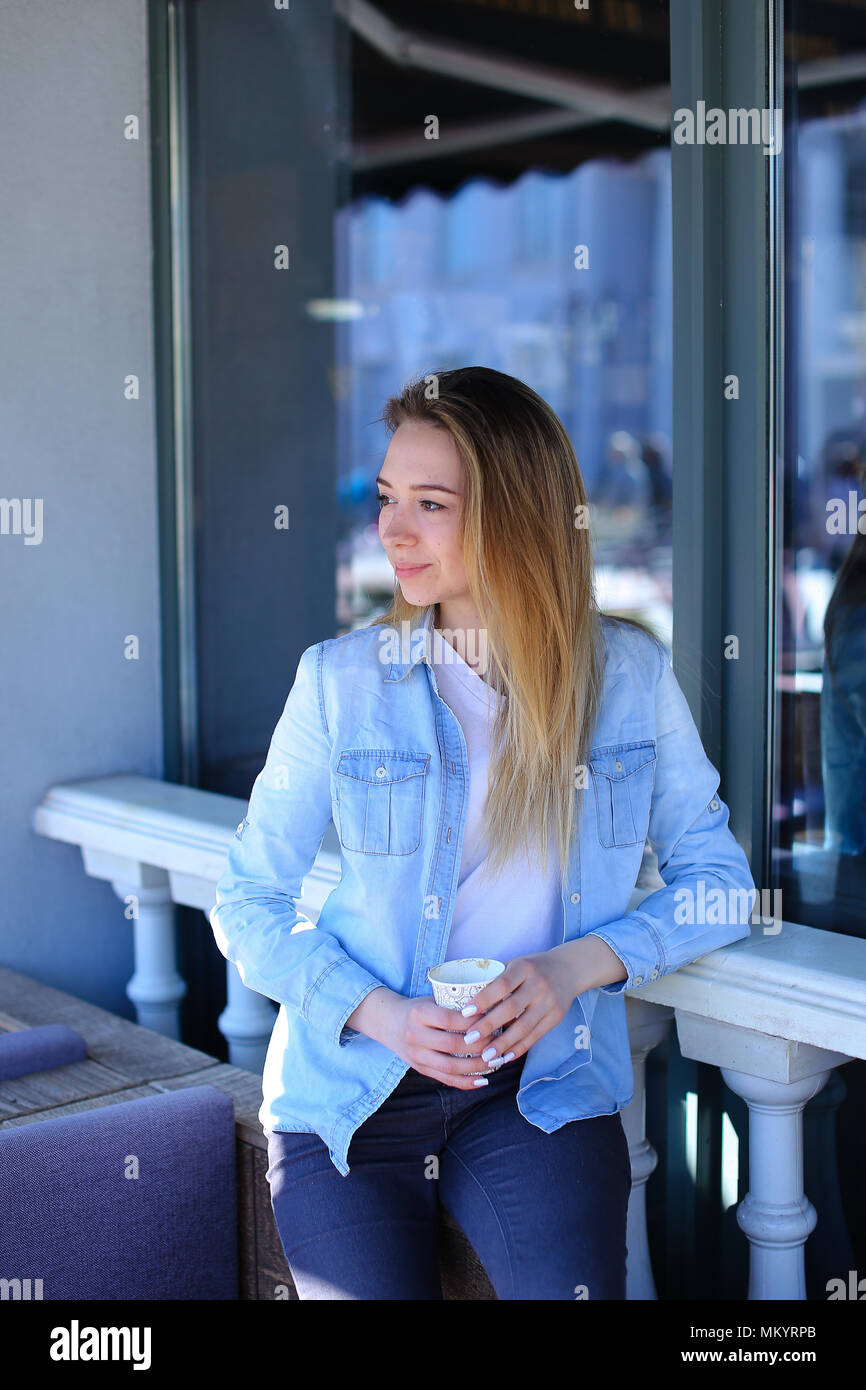 Pretty girl sitting near window and drinking tea Stock Photo - Alamy
