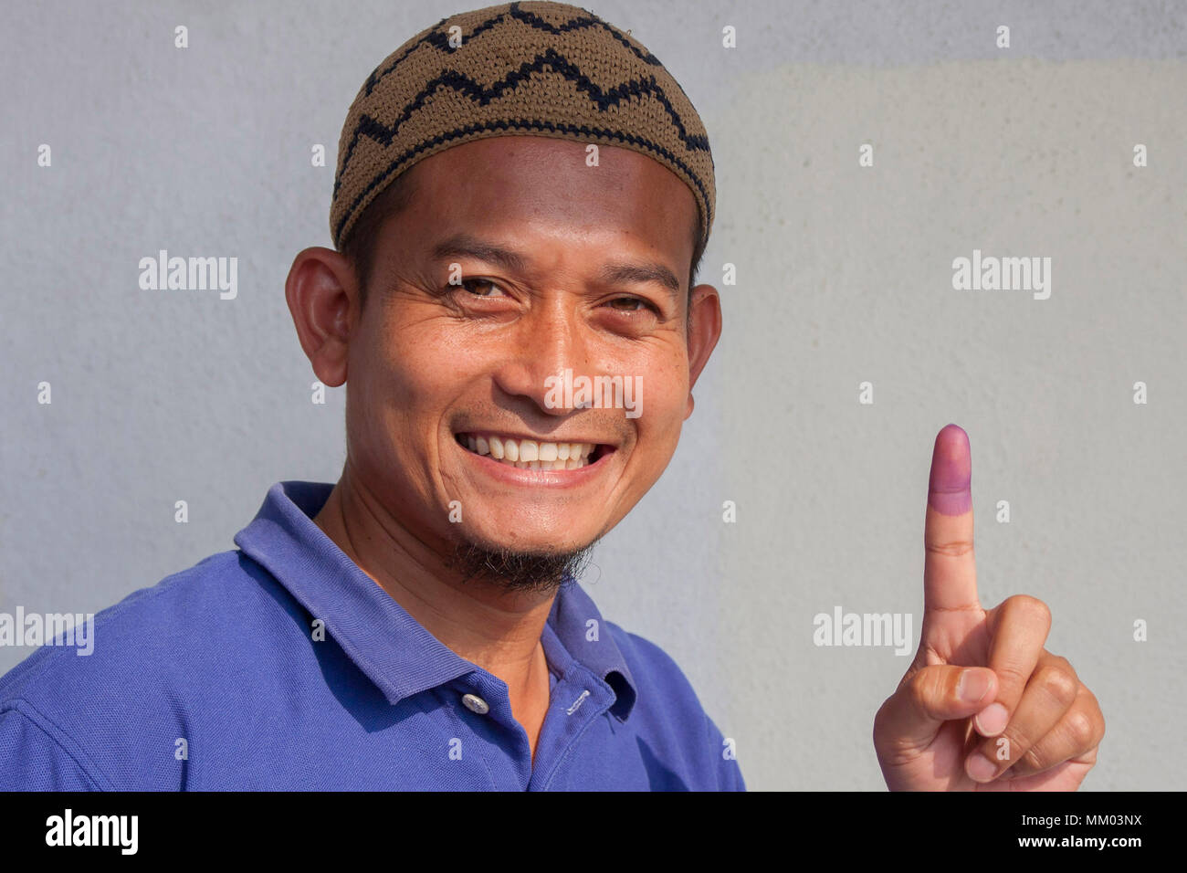 Voter seen posing with his inked finger at a polling station during the ...