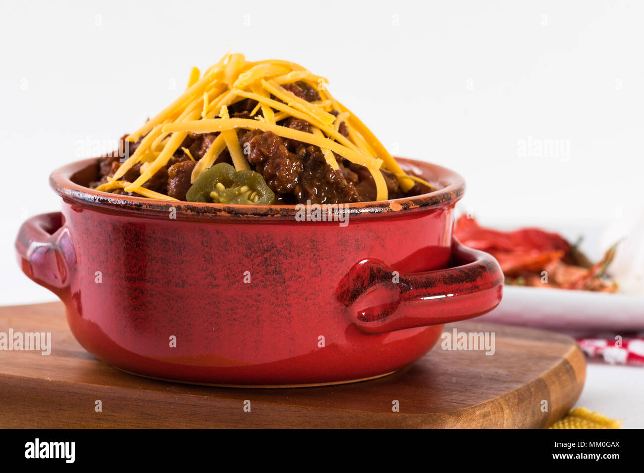 spicy Beef and Bean Chili with cheddar cheese, on white, with copy ...