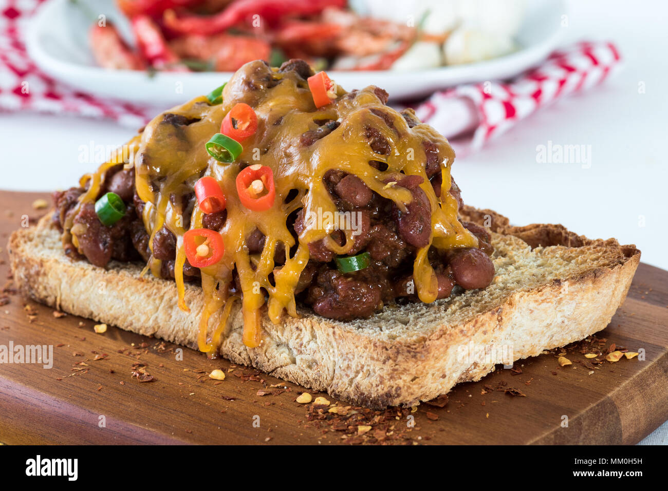 Spicy beef and bean chili on toast covered in melted cheddar cheese ...