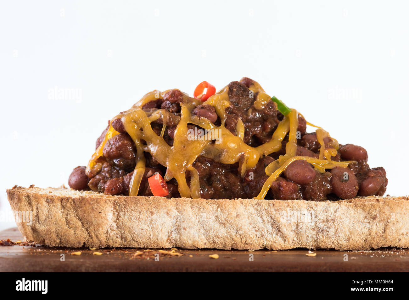 Spicy beef and bean chili on toast covered in melted cheddar cheese ...