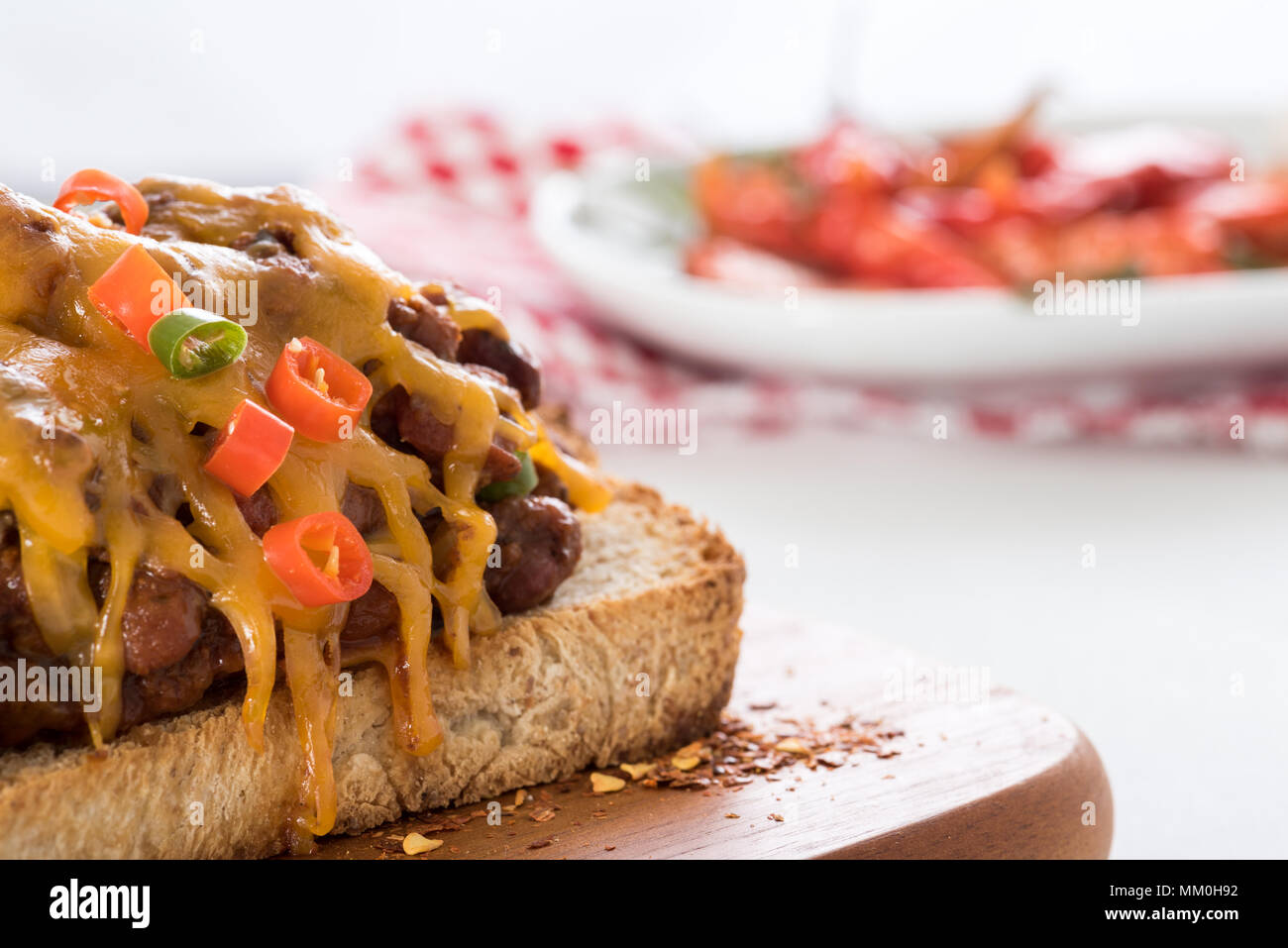 Spicy beef and bean chili on toast covered in melted cheddar cheese ...