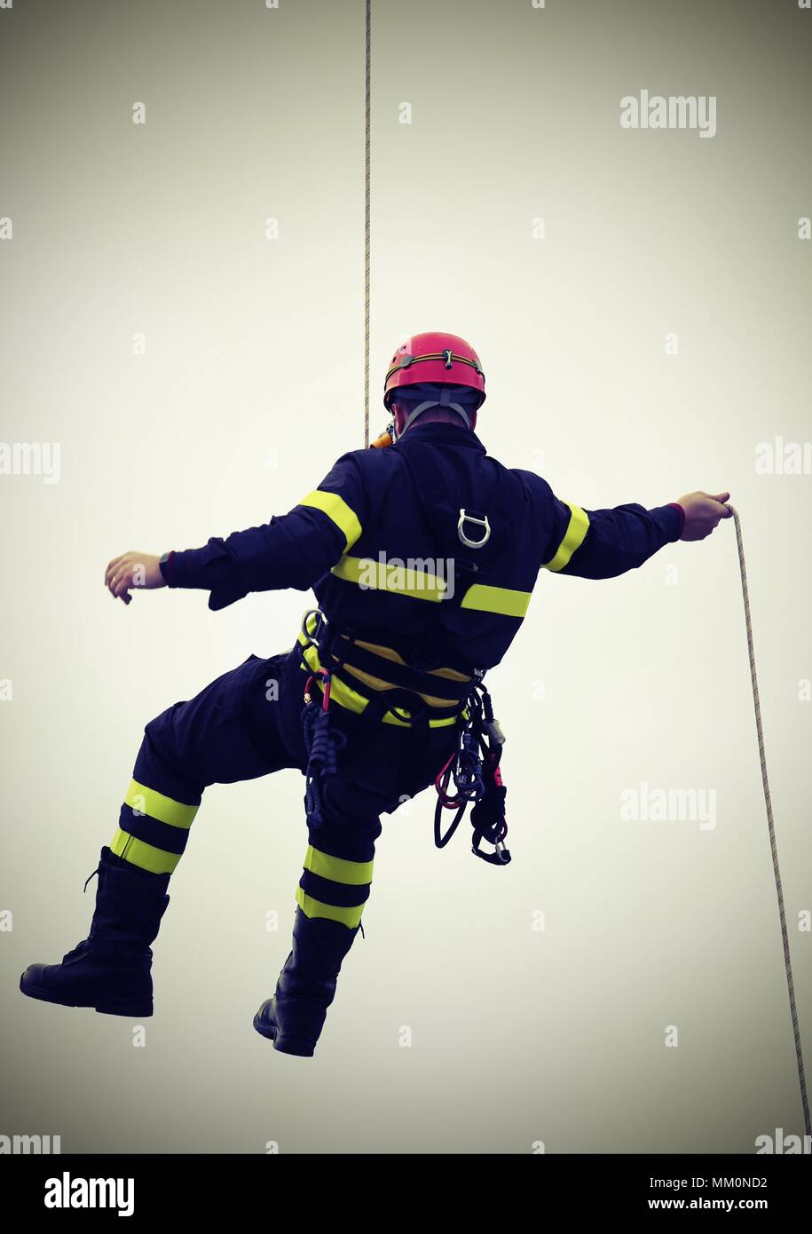 fireman hanging from a cord suspended during an exercise with vintage ...