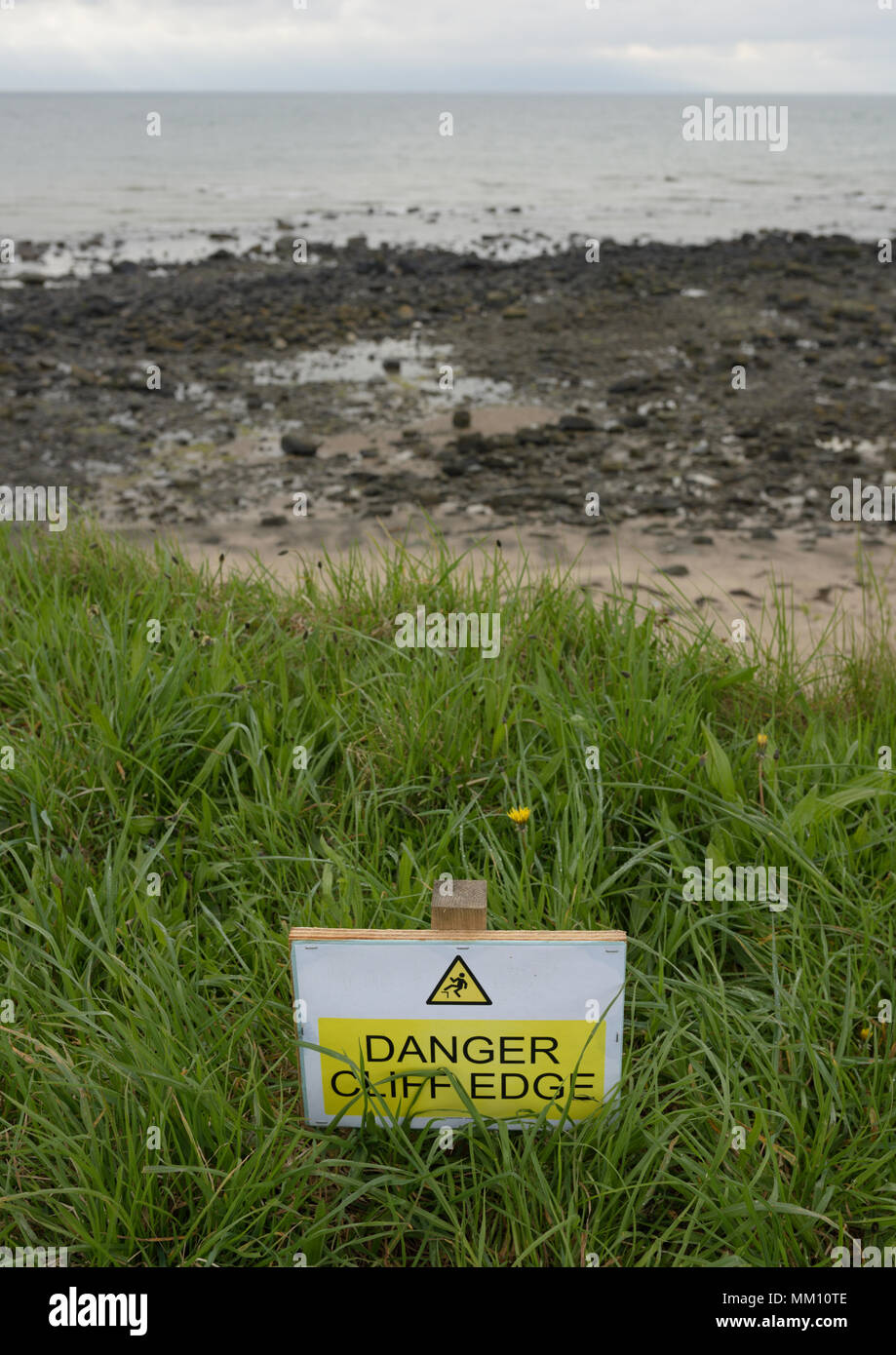 Yellow and white Danger cliff edge warning sign on wales coast path ...