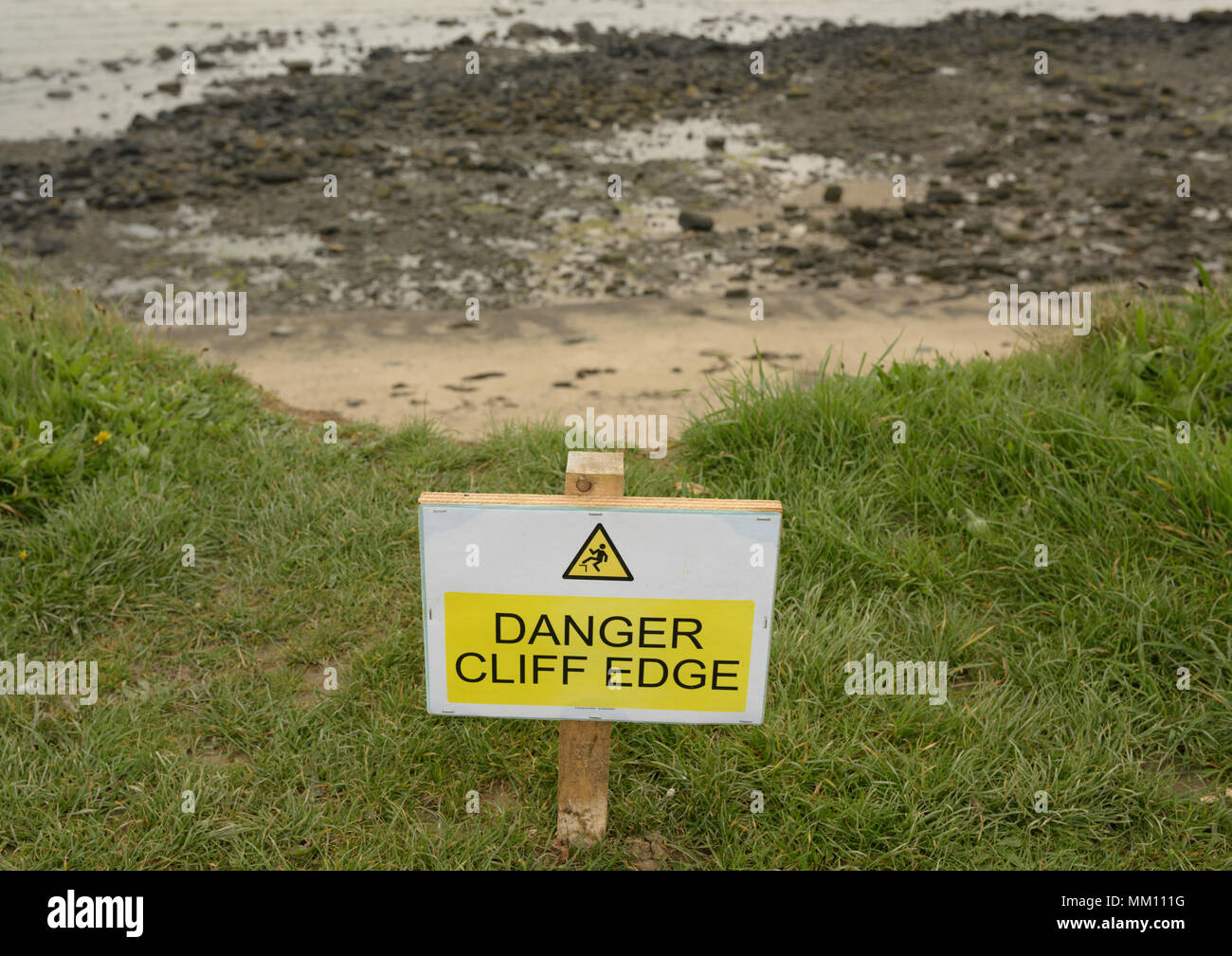 Yellow and white Danger cliff edge warning sign on wales coast path ...