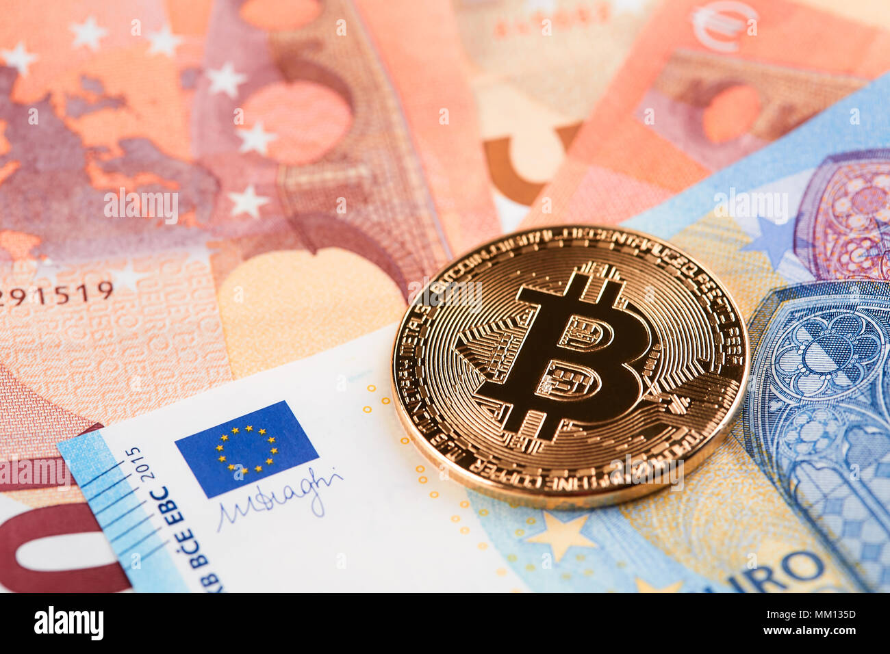 Golden bitcoins stacked on euro banknotes background Stock Photo - Alamy