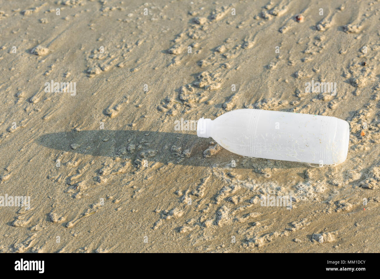 Discarded water bottle laying on a beach Stock Photo - Alamy