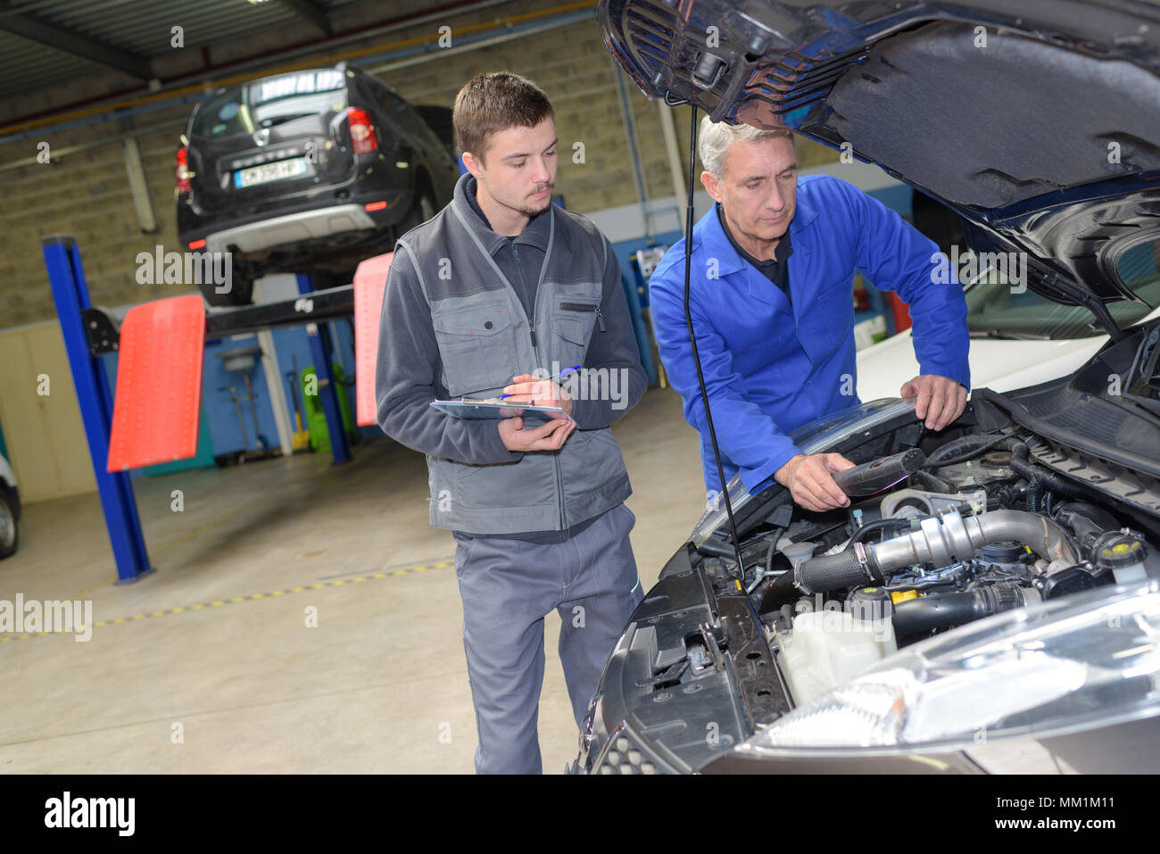 student with instructor repairing a car during apprenticeship Stock ...