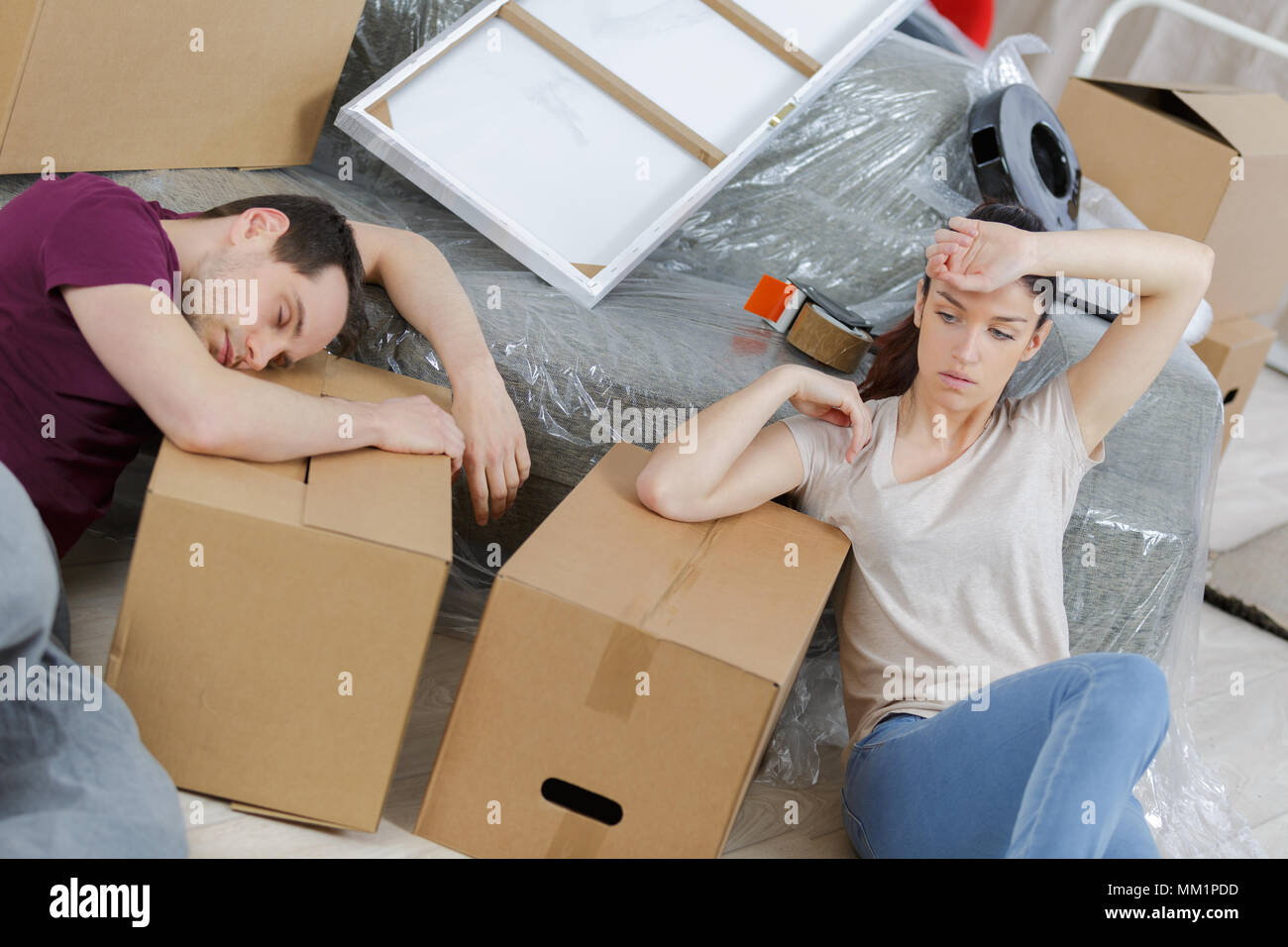 tired couple resting in new home during moving Stock Photo - Alamy