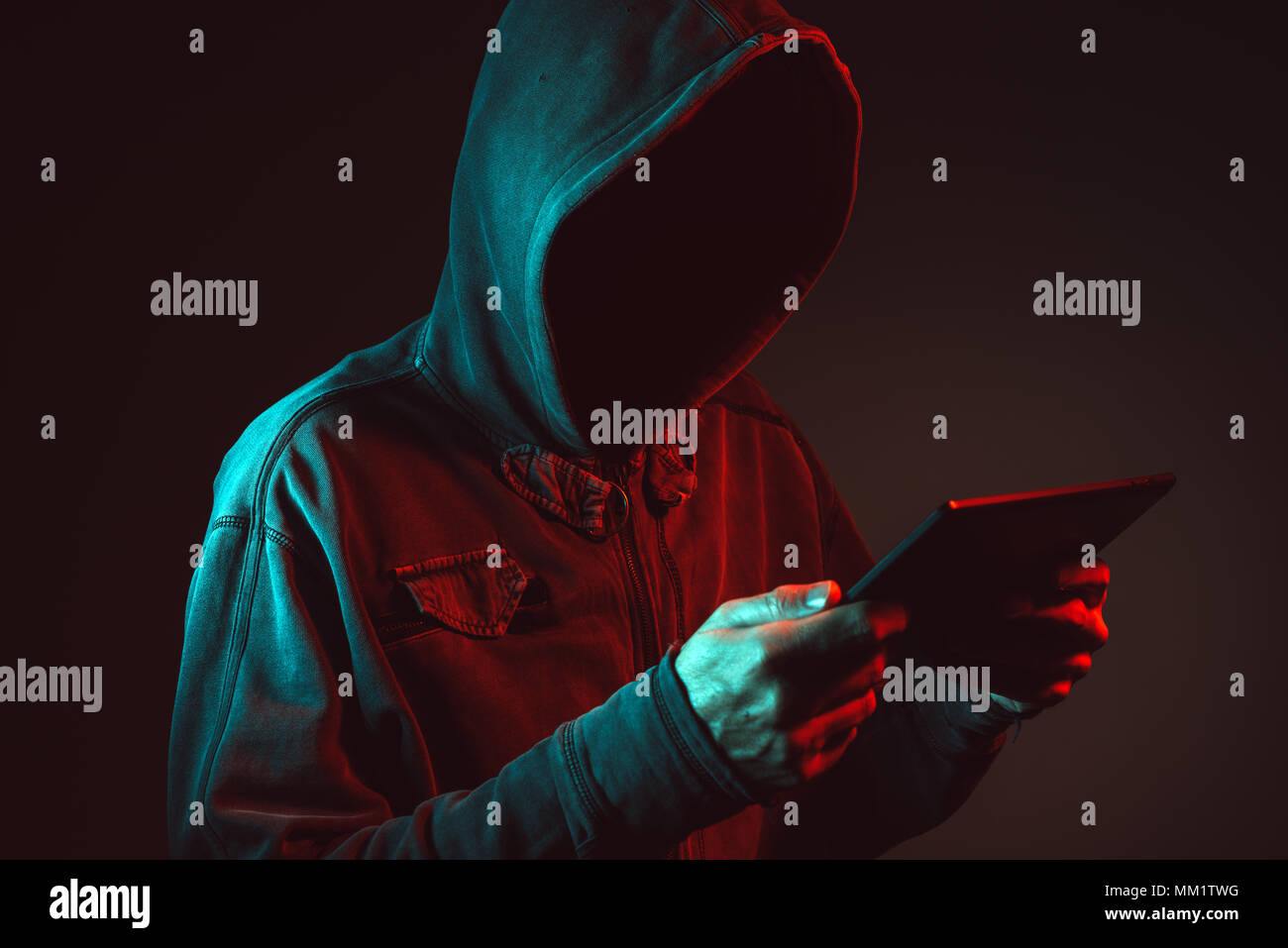 Hacker using tablet computer, red and blue lit low key image Stock ...