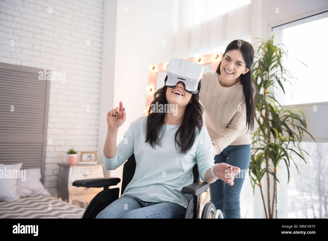 Joyful two friends immersing in VR Stock Photo - Alamy