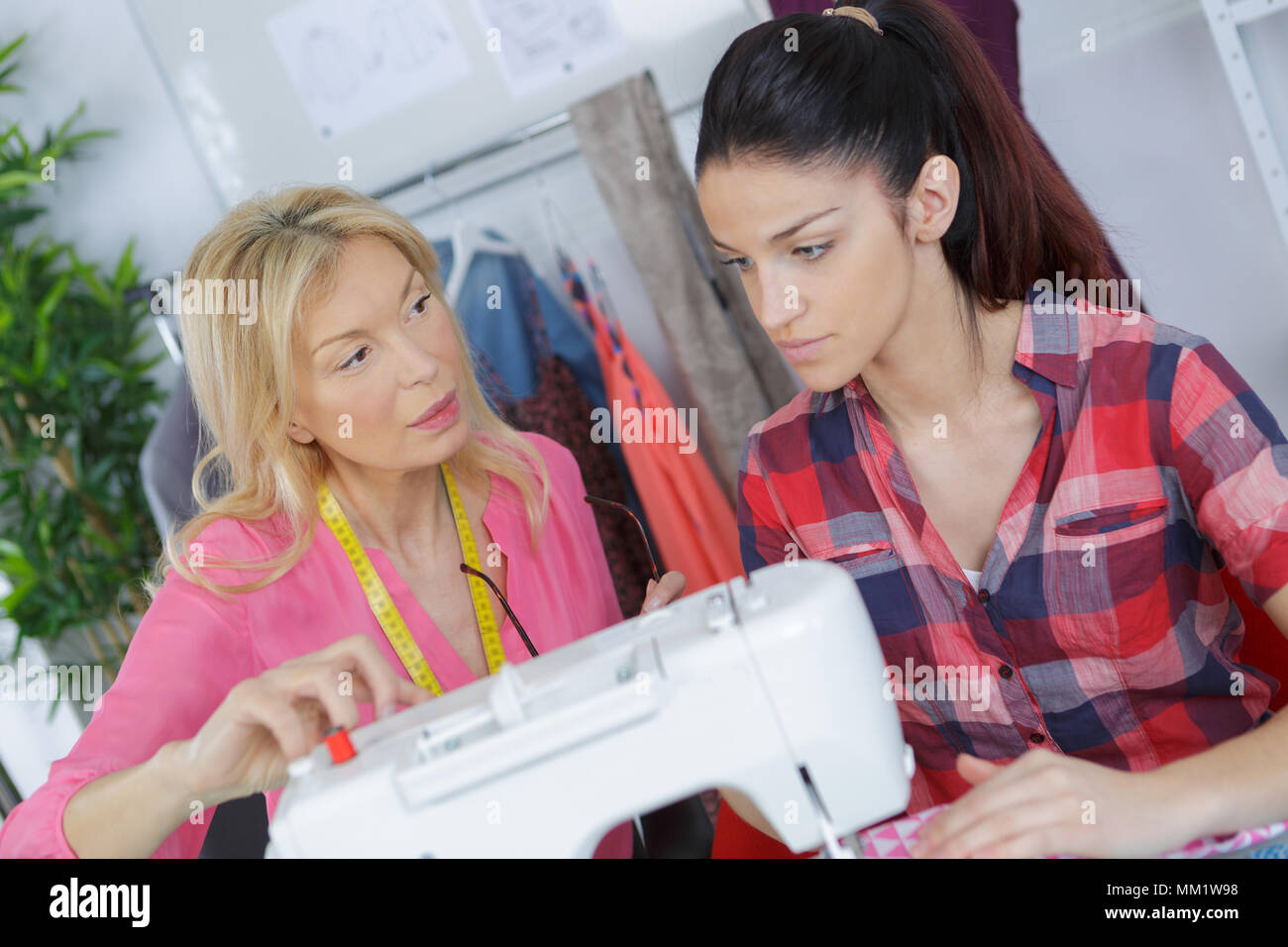 woman in dressmaking class helping student Stock Photo - Alamy