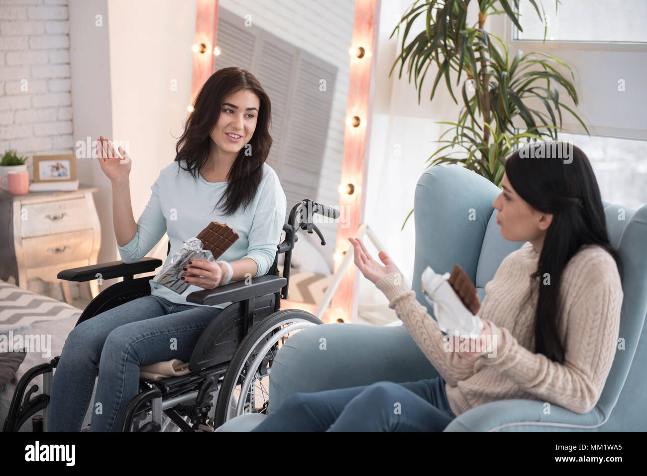 Happy two friends eating chocolate Stock Photo - Alamy