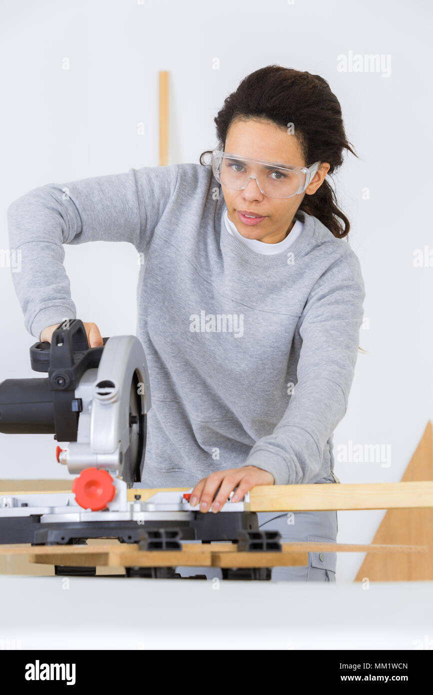Young woman using circular saw Stock Photo - Alamy