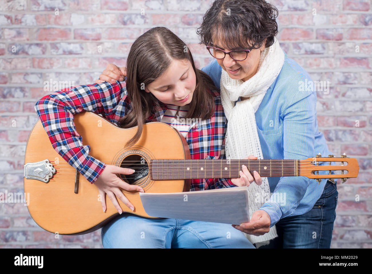 a young teenager learning to play the guitar with his teacher Stock ...
