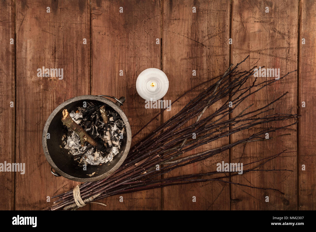 An overhead photo of a witch's cauldron, a candle, and a handmade broom ...