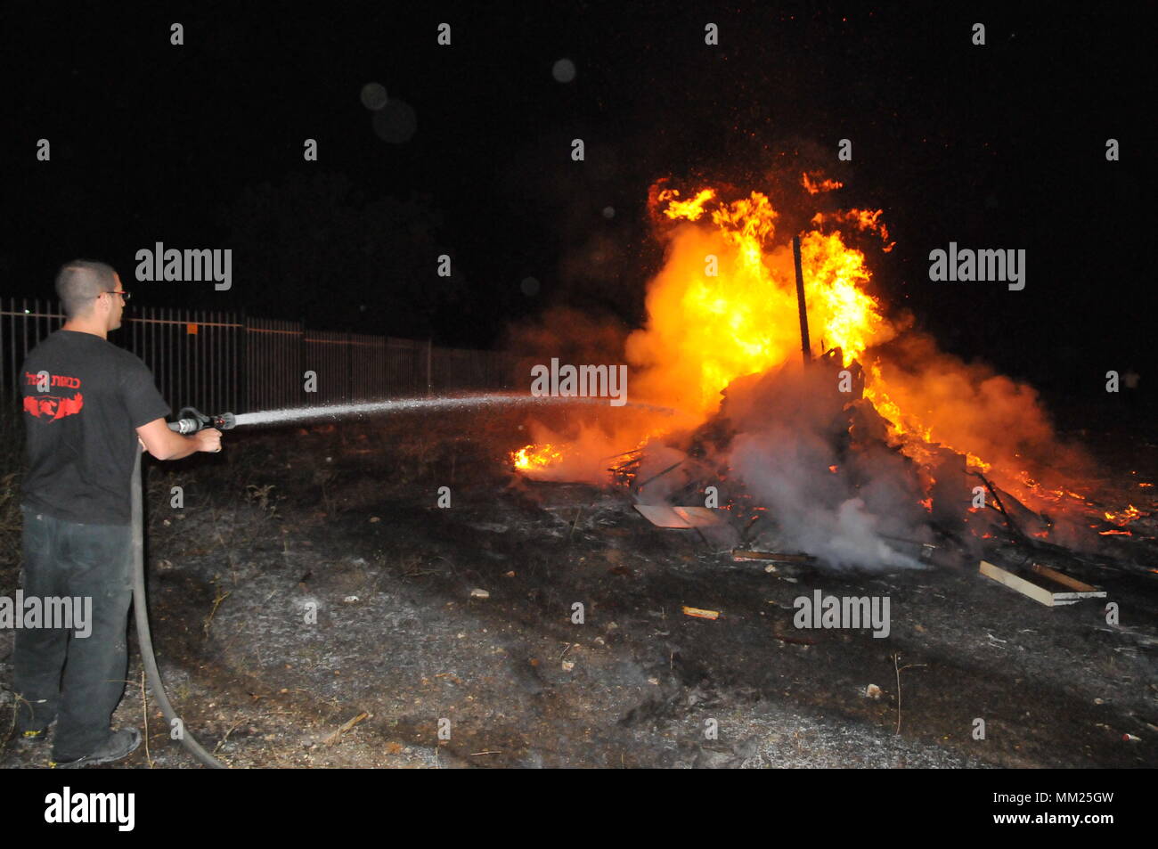 Firefighter extinguish a large bonfire during the lag b'omer ...