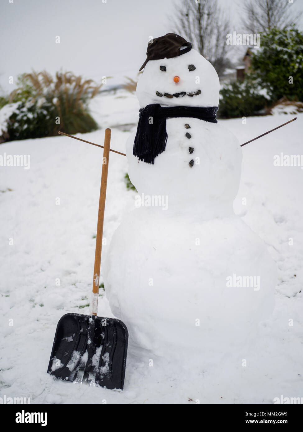 Snowman with snow shovel Stock Photo - Alamy
