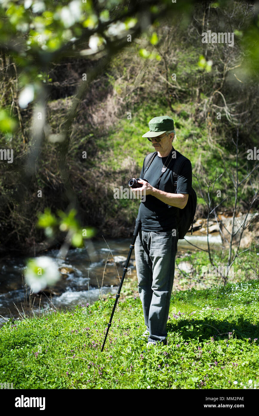Senior man with his camera on a hiking trip Stock Photo - Alamy