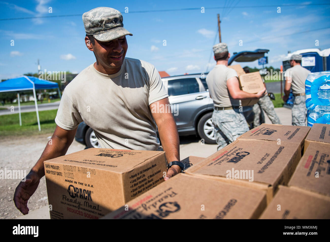Soldiers assigned to the Texas National Guard load boxes of Meal-Ready ...