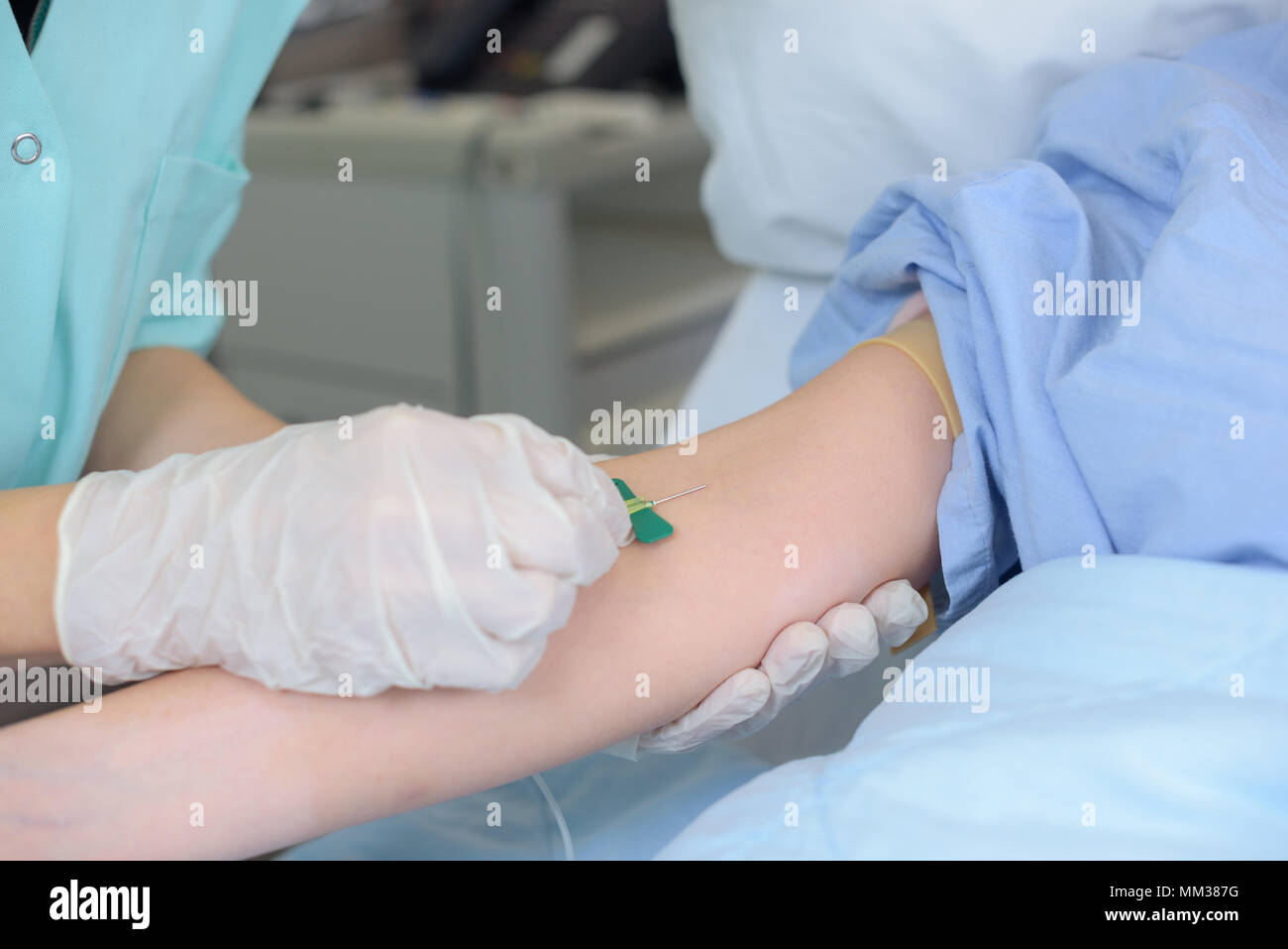 Needle being inserted into patient's arm Stock Photo - Alamy