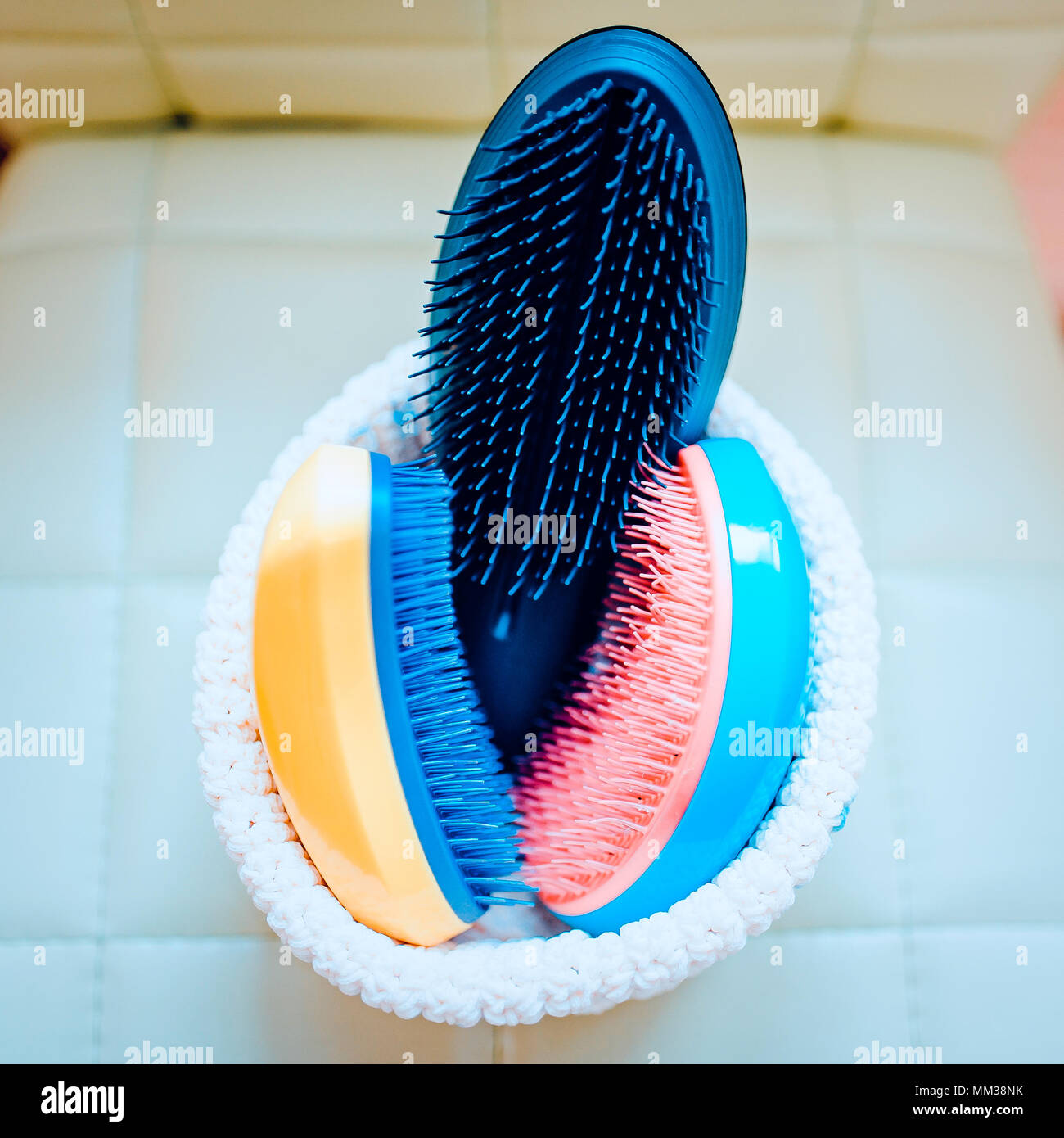 Basket with combs and round hair brushes. Toned image. Comb for combing ...