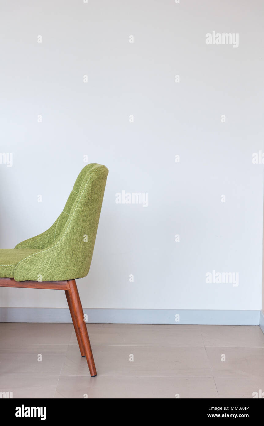 Close up green chair modern style on white concrete corner background ...