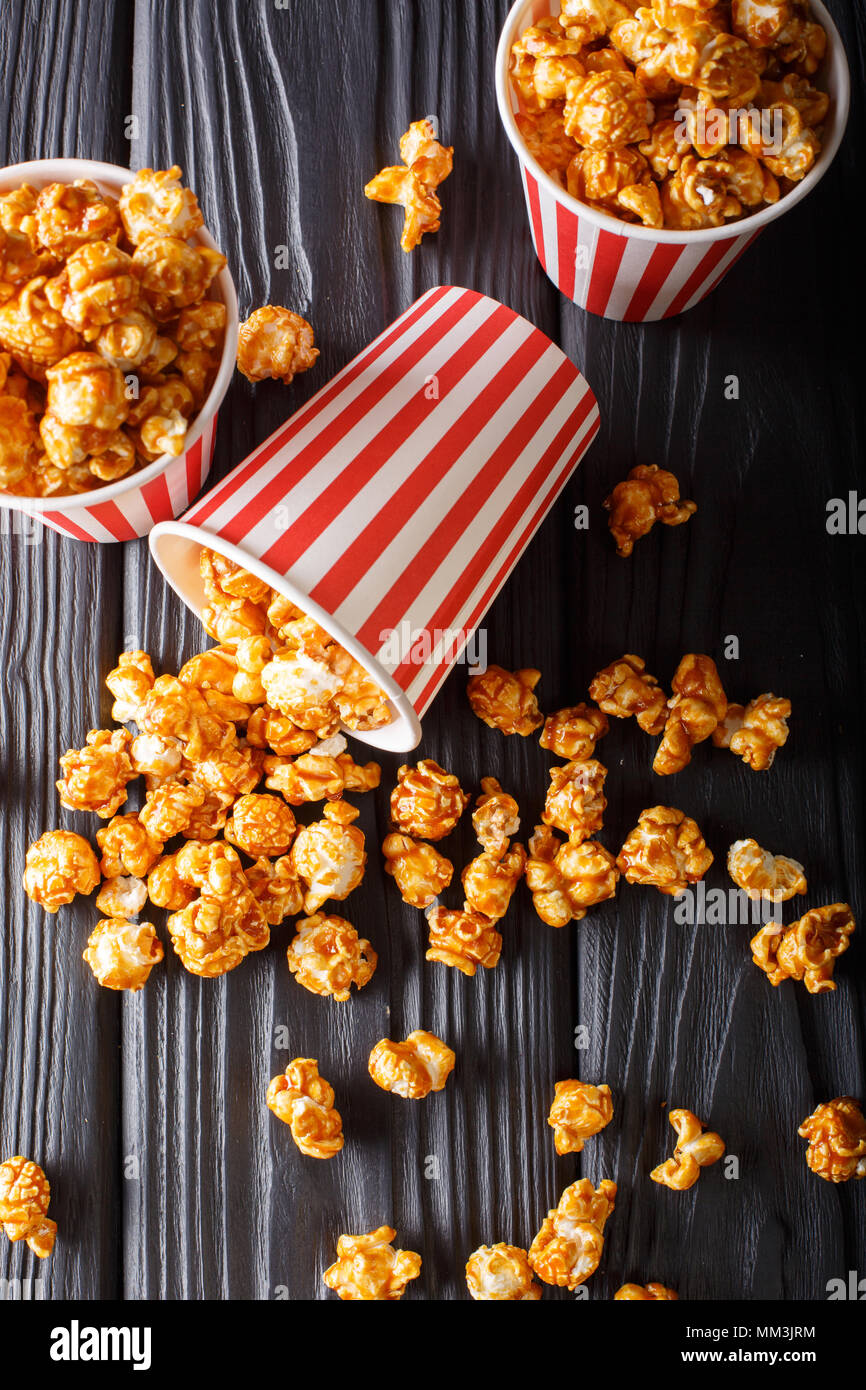 three striped boxes of sweet caramel popcorn close-up on wooden ...