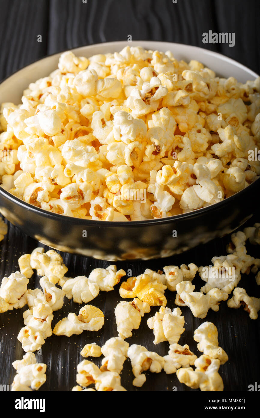 Delicious cheesy popcorn in a bowl close-up on a table. vertical Stock ...